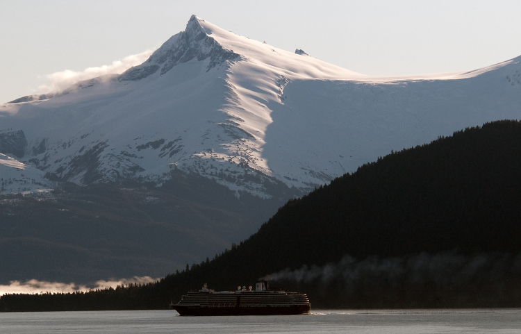 ship sailing in the waters off alaska with snow covered mountain ...