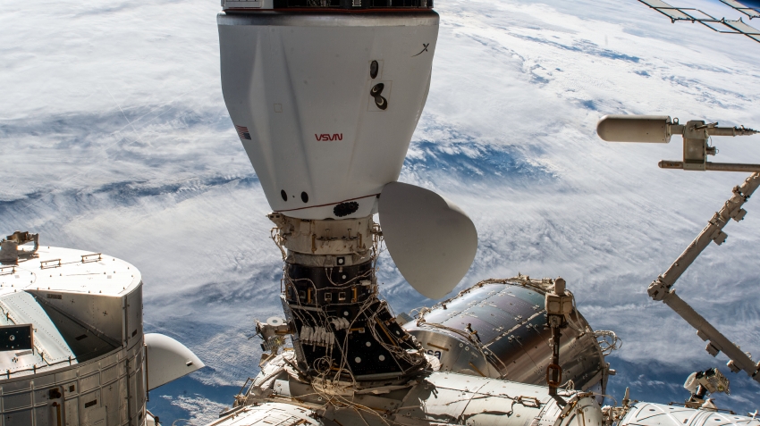 the spacex cargo dragon cargo craft is pictured docked to the sp ...