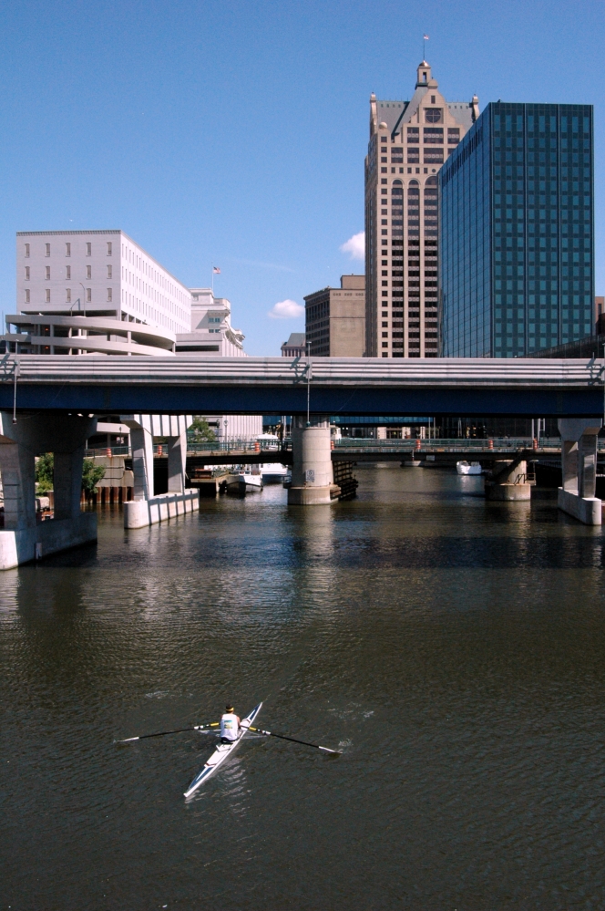 View of downtown Milwaukee with single crew row boat on river ...